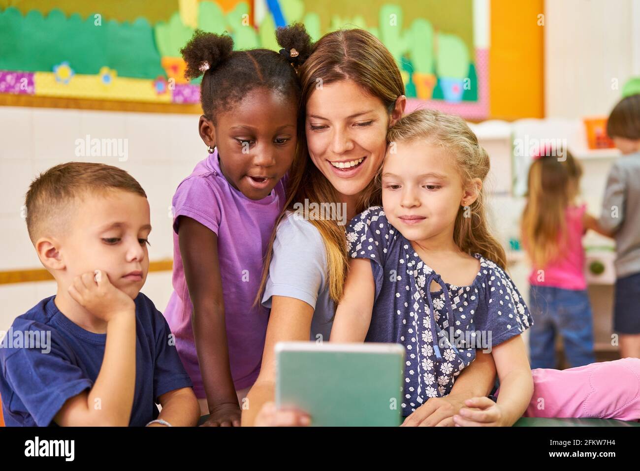 Multicultural children and educators have fun making selfies with the ...