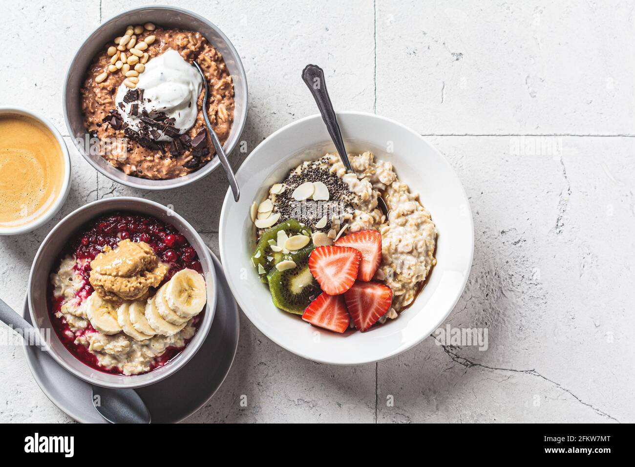 Assorted oatmeal bowls with chocolate, fruit and yogurt, gray tiles ...