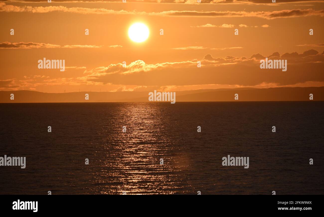 The sun slowly setting and shining on the water Stock Photo - Alamy