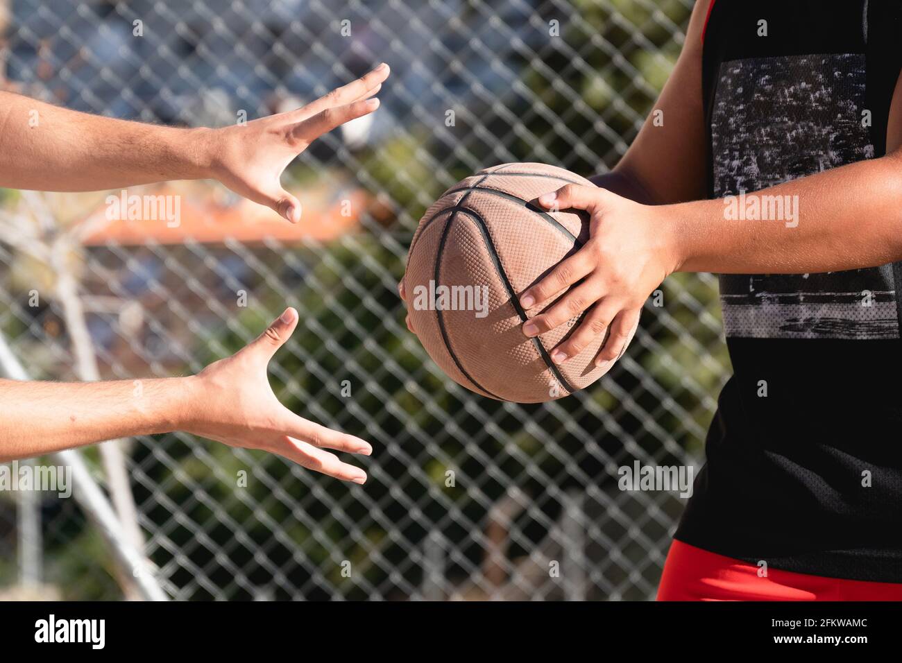 View at two players passing the basketball ball on the street court ...