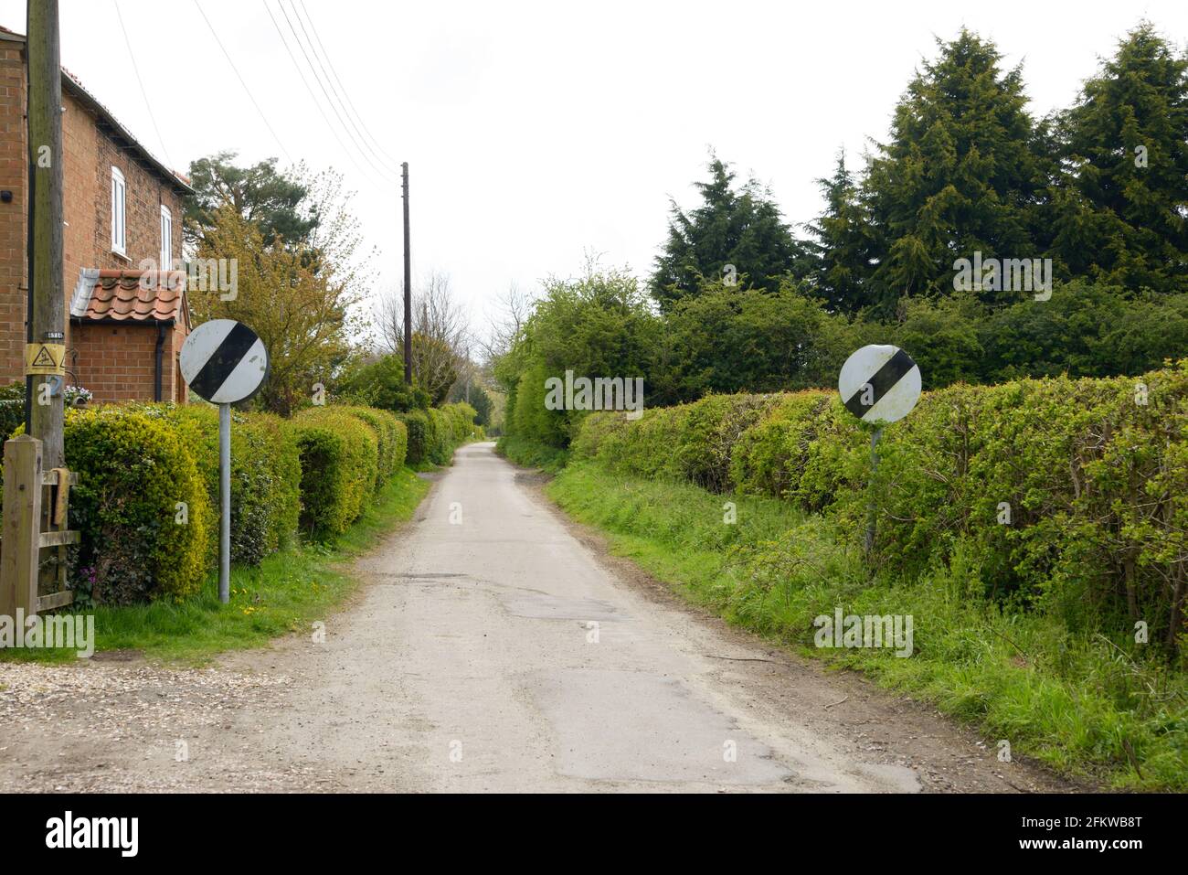 Crazy signs, showing no speed limit on very narrow lane Stock Photo - Alamy