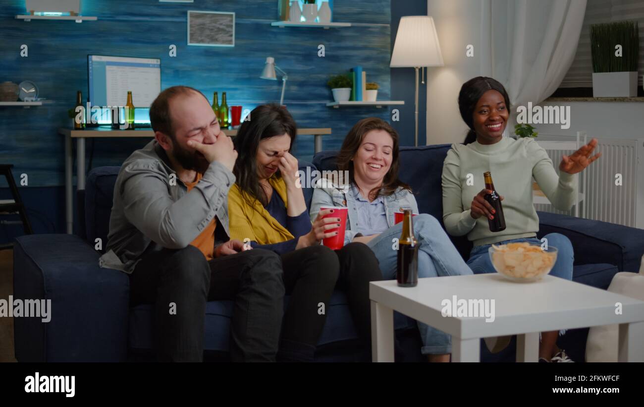 Happy multiethnic friends smiling together while sitting in frot of ...