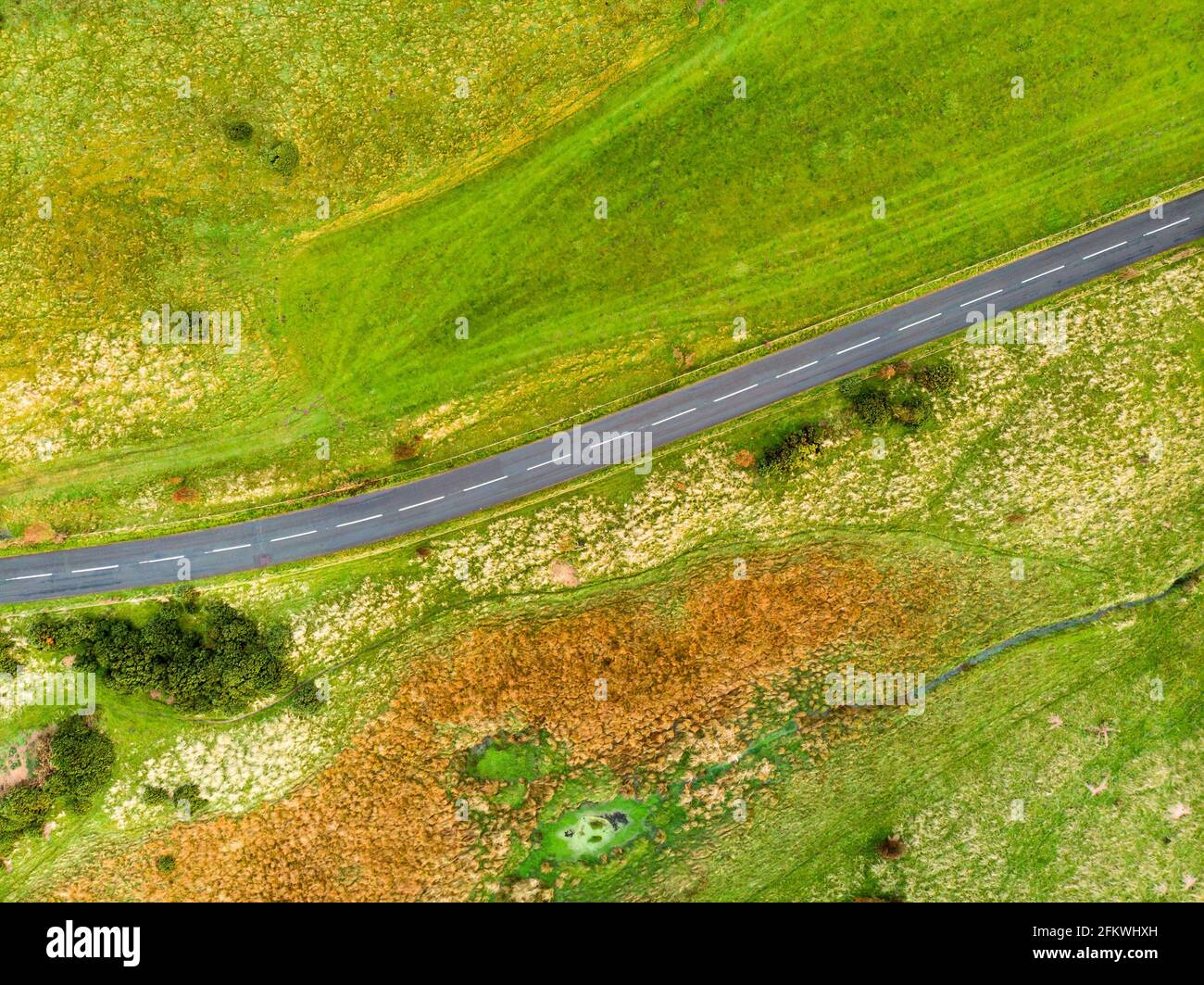 Aerial top down view of two-lane road in the Lake District, famous for ...