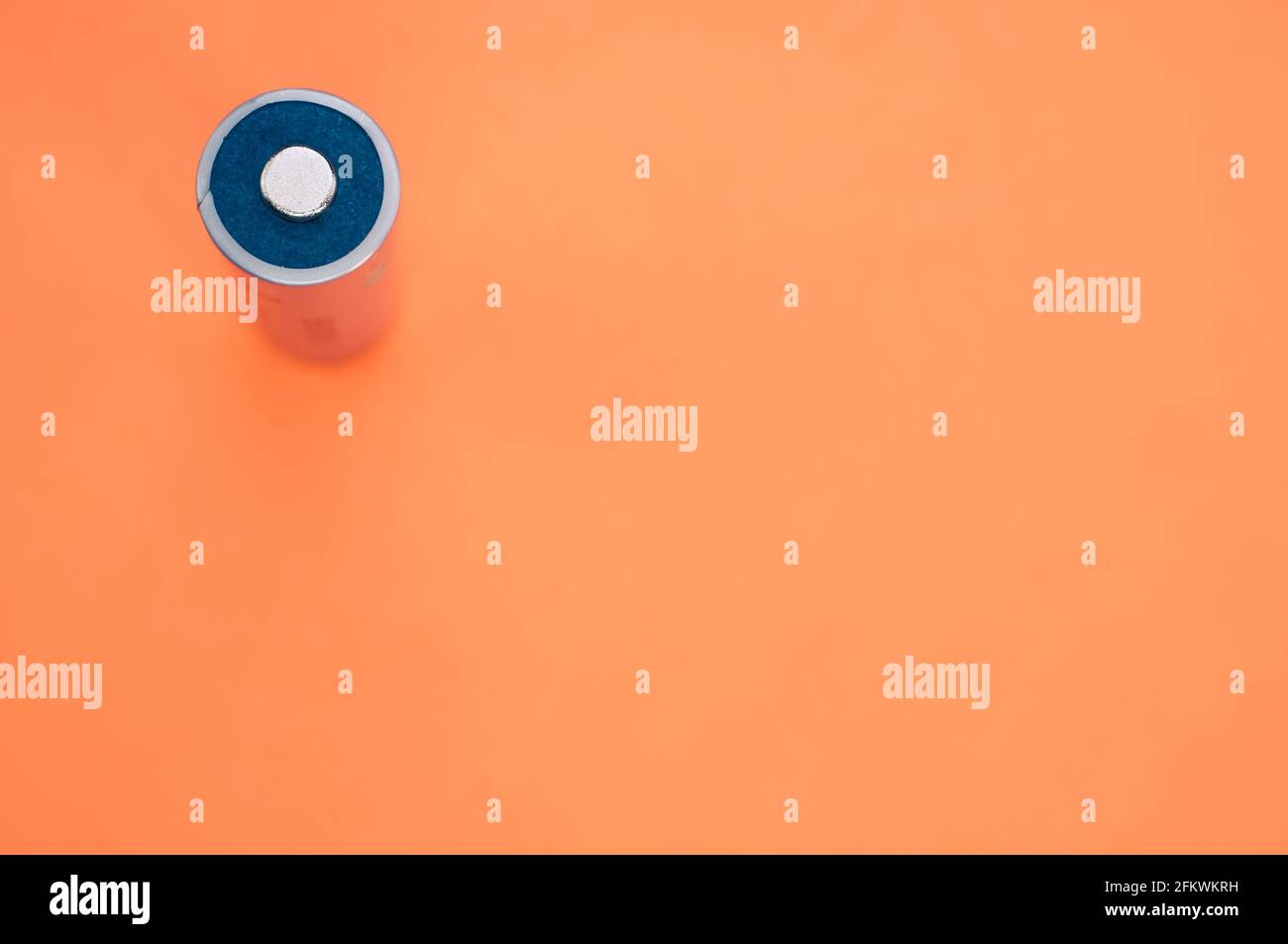 Top view of a battery on a light orange background Stock Photo - Alamy