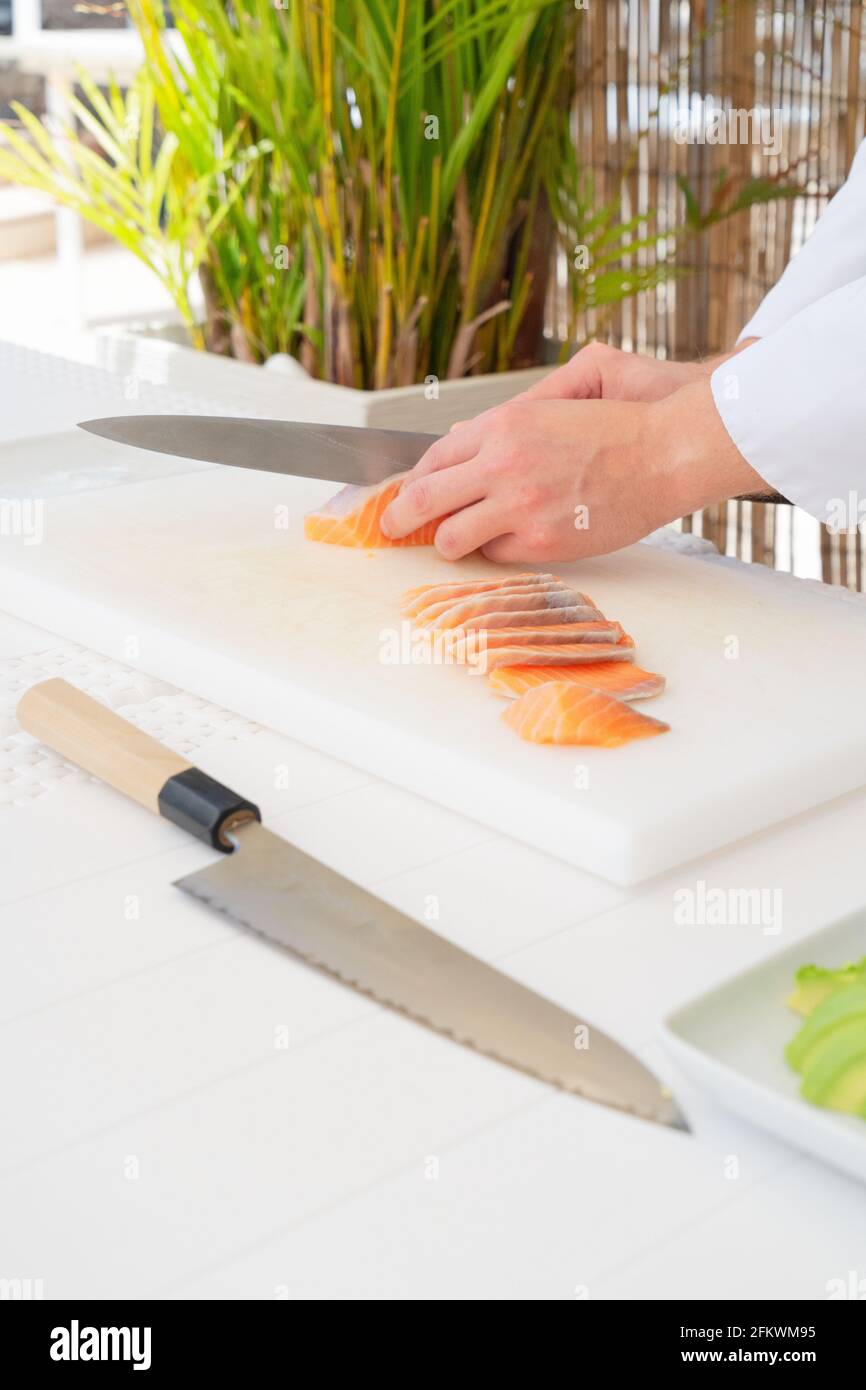 Male chef in uniform cutting fresh salmon for sashimi Stock Photo - Alamy