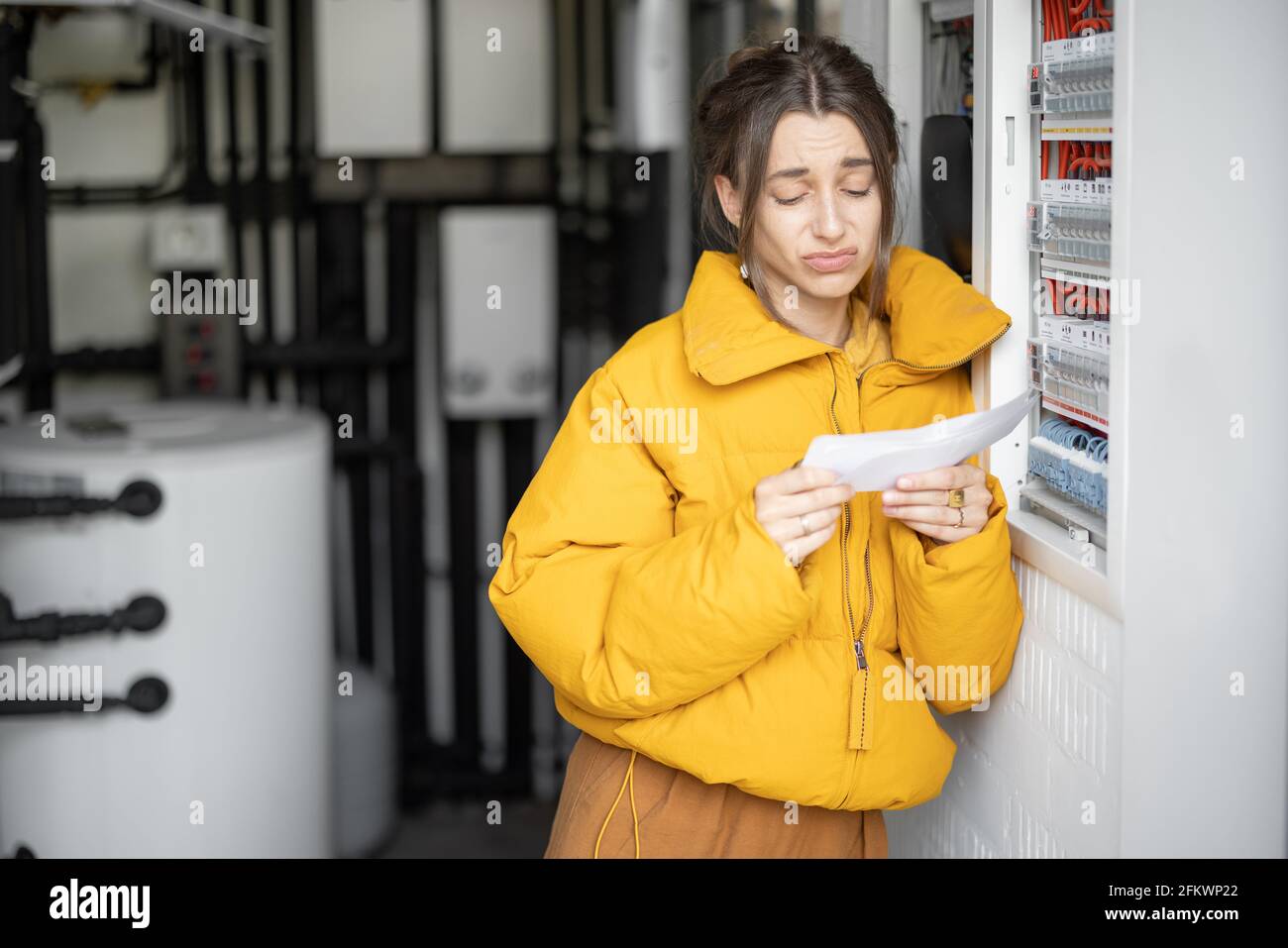 Confused woman looks at electricity bills, comparing data with the ...