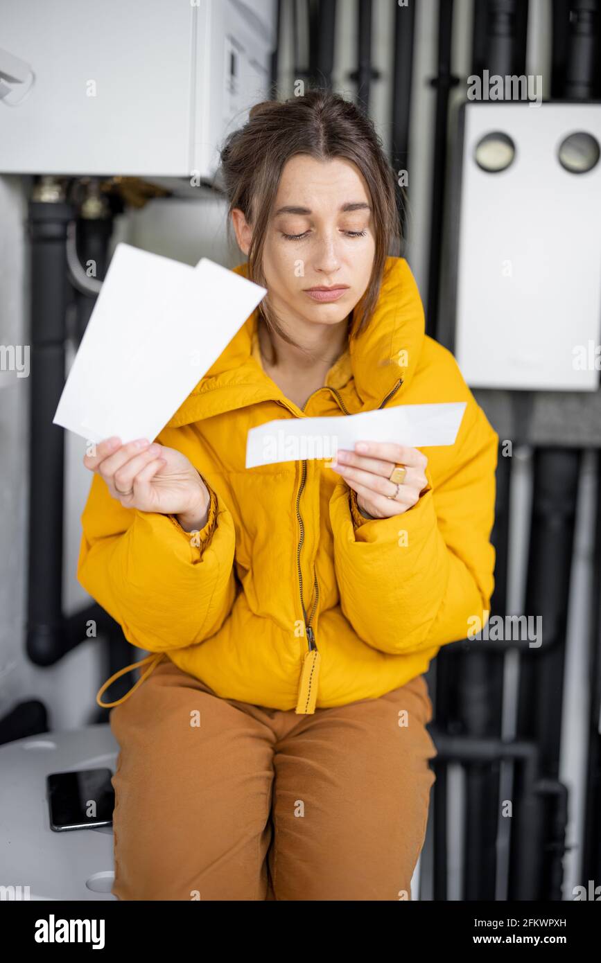 Confused woman looks at electricity bills, comparing data with the ...