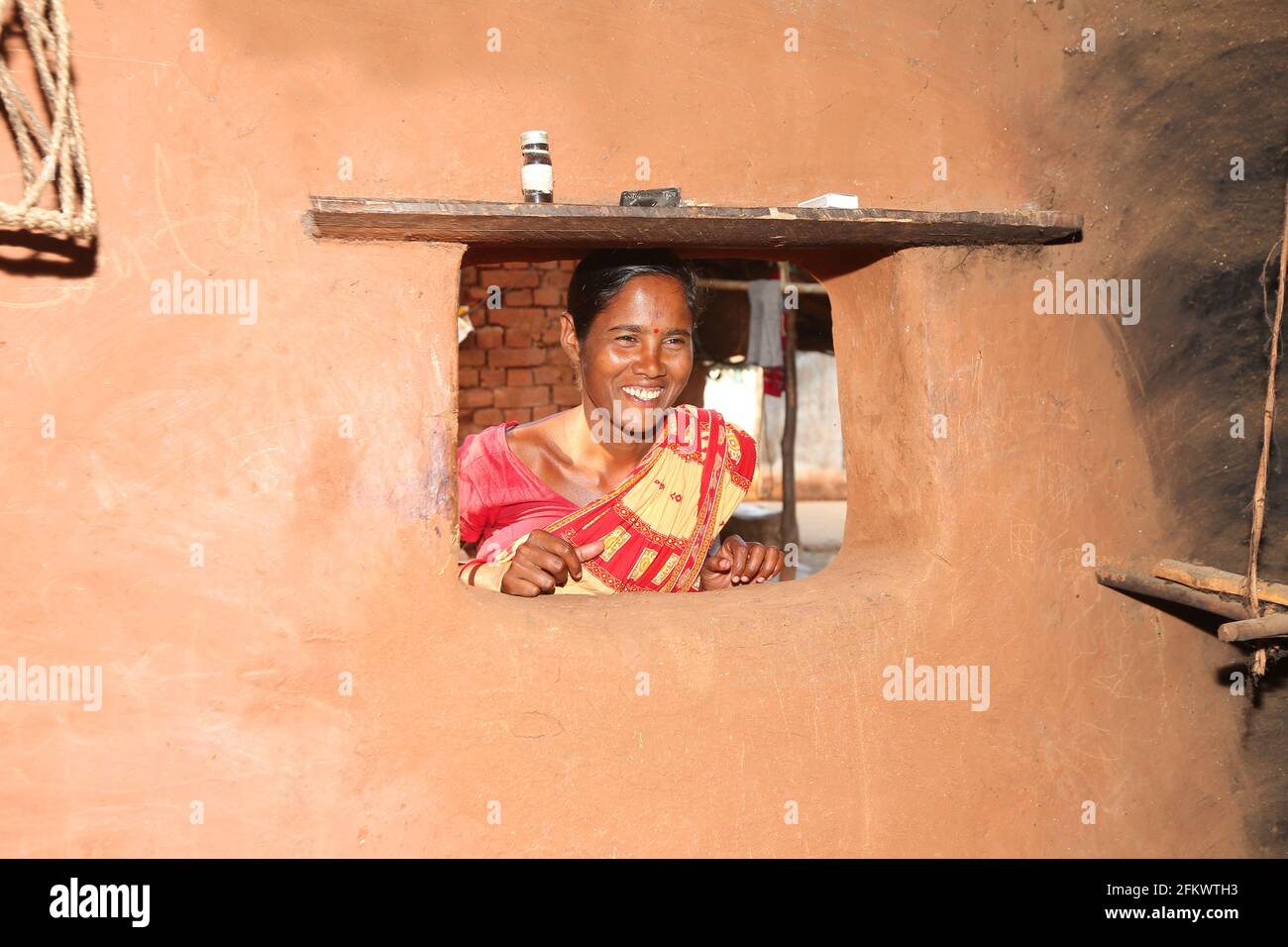 Woman smiling from mud house window. DESIA KONDHA TRIBE. Goipeta ...