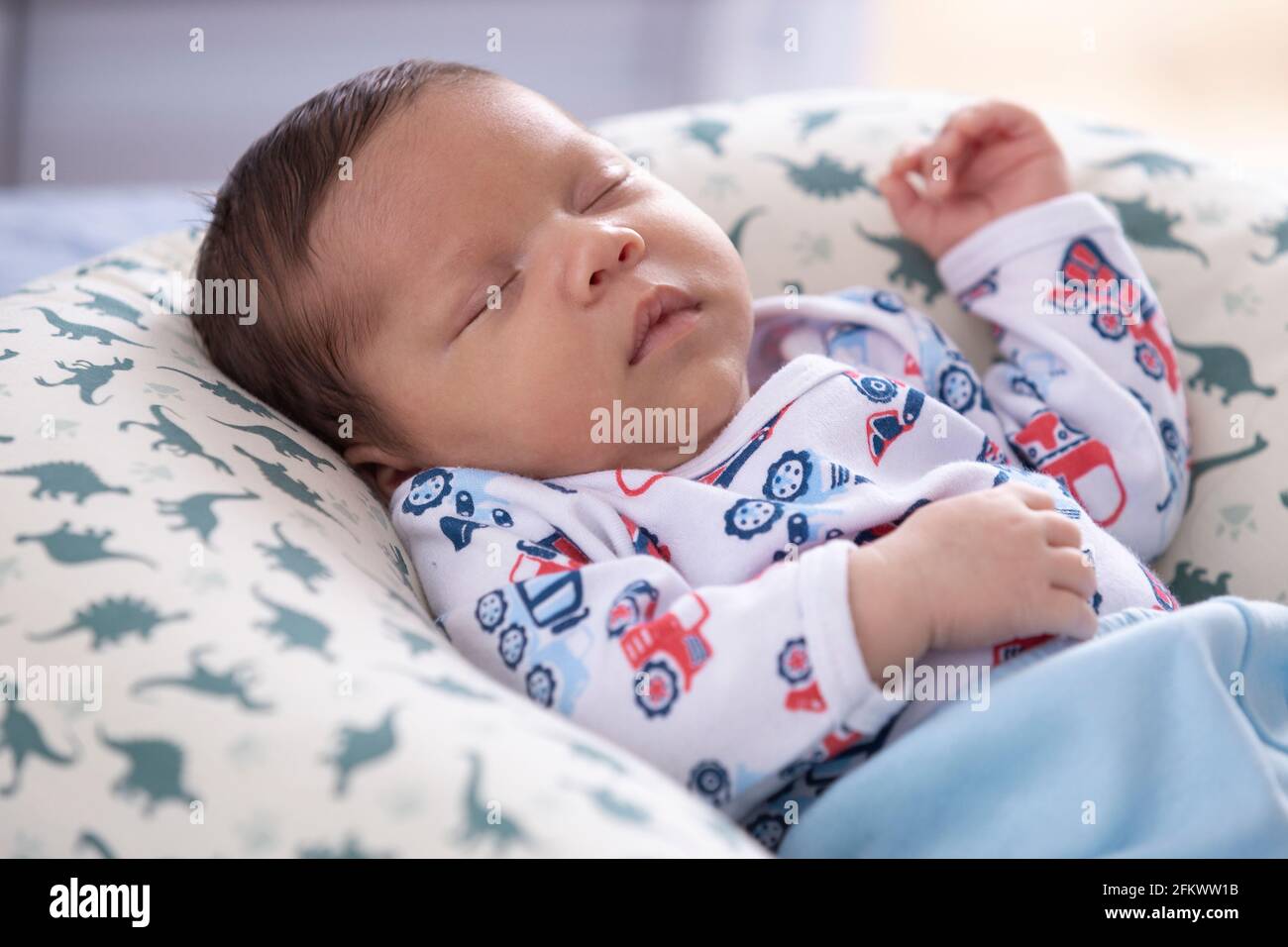 baby relaxed in bed, sleeping and with raised arm Stock Photo - Alamy