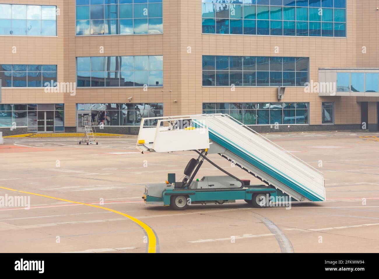 Passenger ladder stair truck rides along the platform near the airport ...