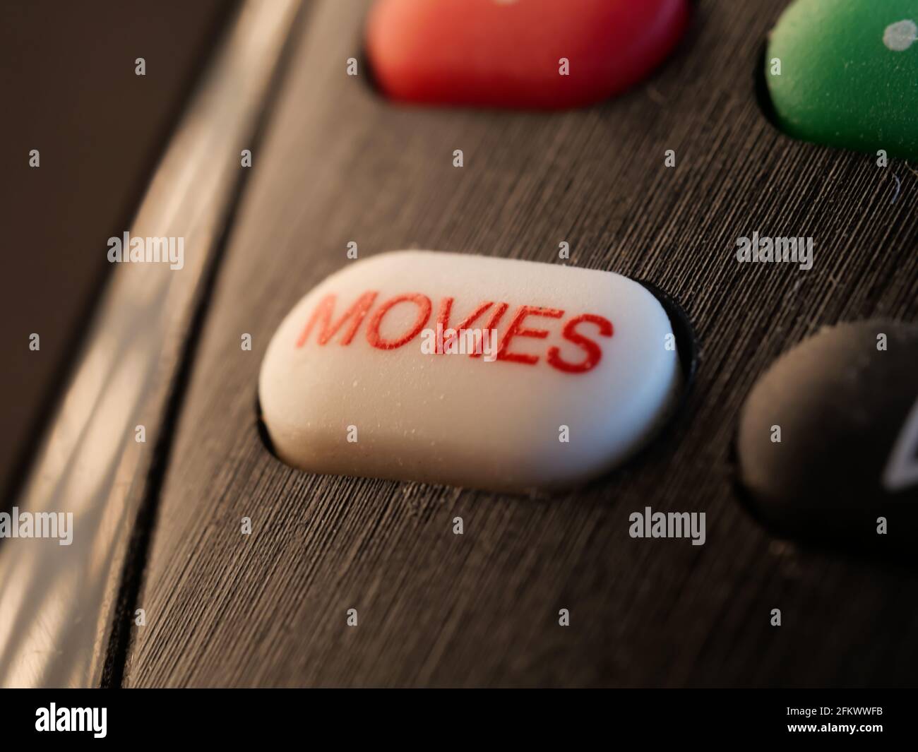 Selective focus shot of remote control with the button of movies in the ...