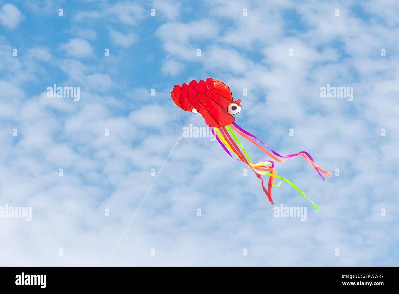 Red kite with long ribbons in the sky and clouds Stock Photo - Alamy