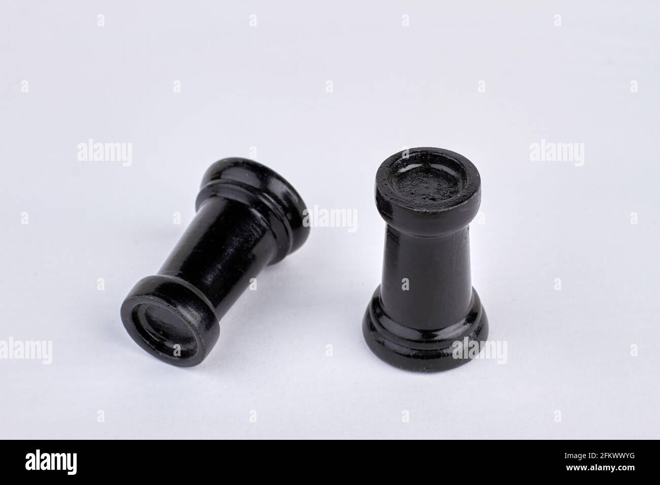 Black rook chess piece stands near fallen chess piece Stock Photo - Alamy