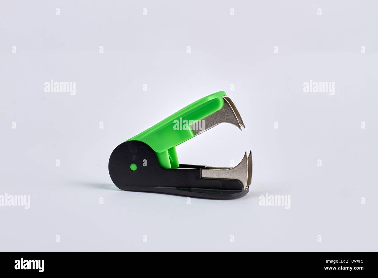 Green stapler remover isolated on white background Stock Photo - Alamy