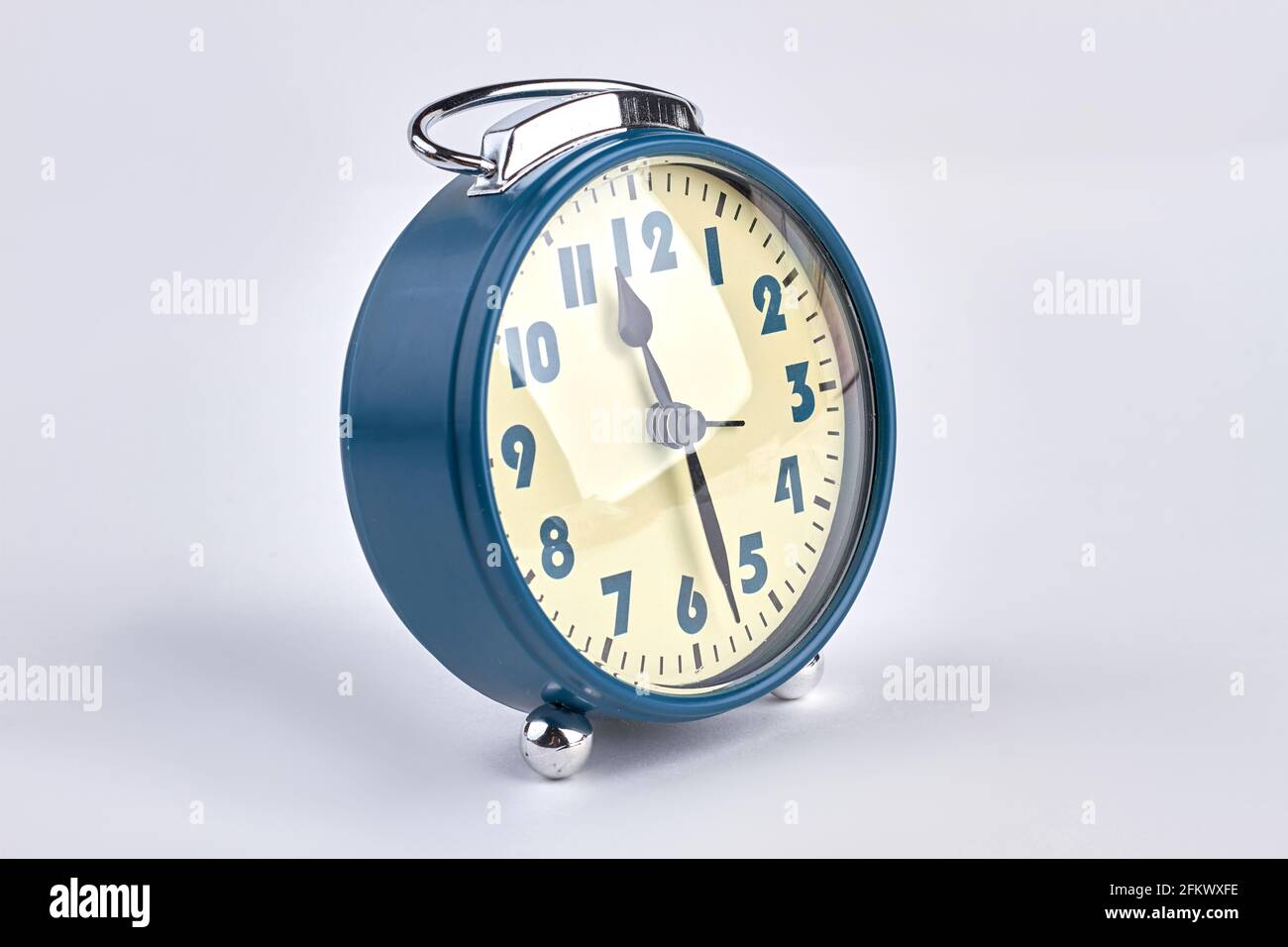 Blue old style alarm clock on white background Stock Photo - Alamy