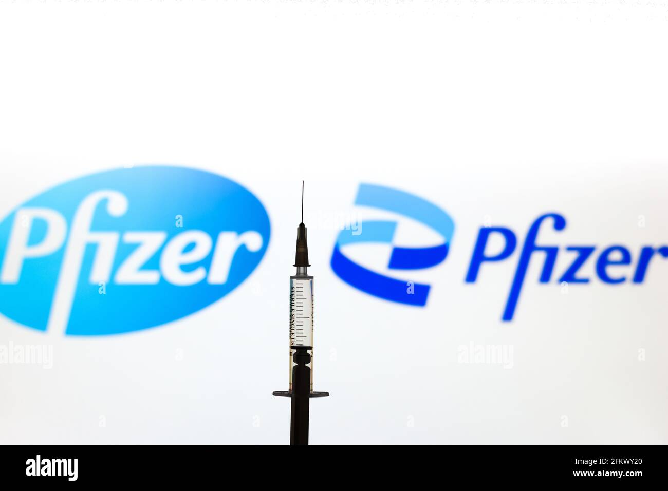 In this photo illustration a medical syringe is seen in front of old ...