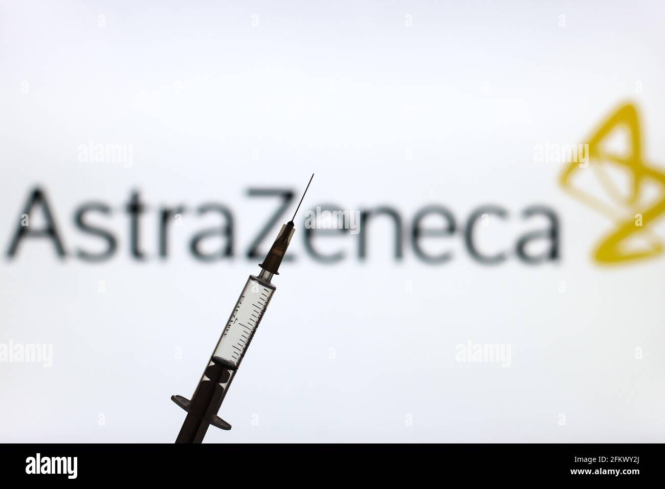In this photo illustration a medical syringe is seen in front of a logo ...