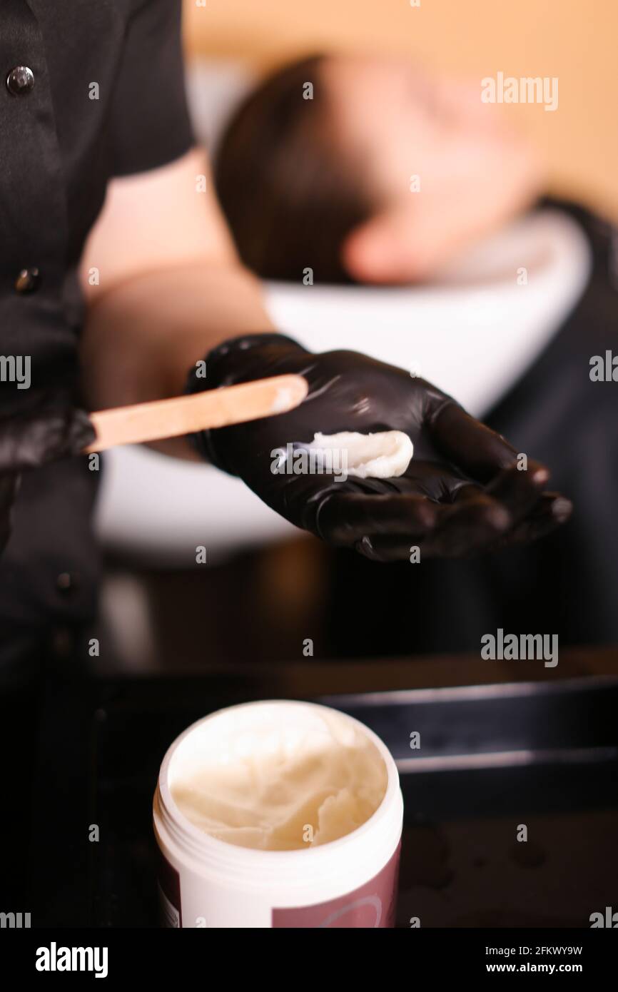 Professional female hairdresser preparing color to female customer at ...