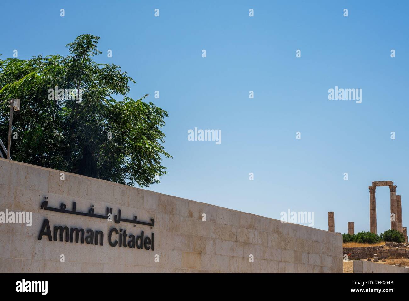 The location entrance sign on a wall of Amman Citadel in English and ...