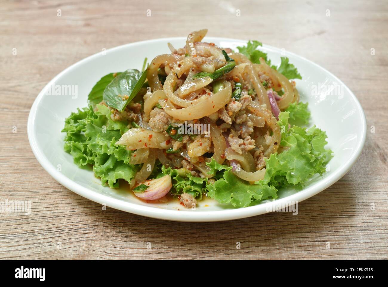 Thai spicy chop pork and slice skin salad with fresh vegetable on plate ...