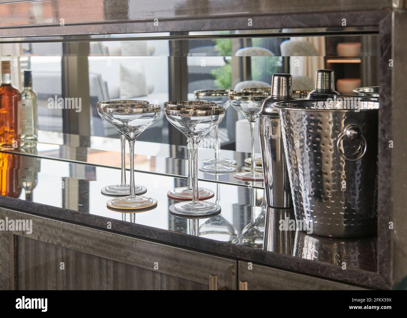 Cocktail glasses, a shaker and an ice bucket on the top of a drinks ...