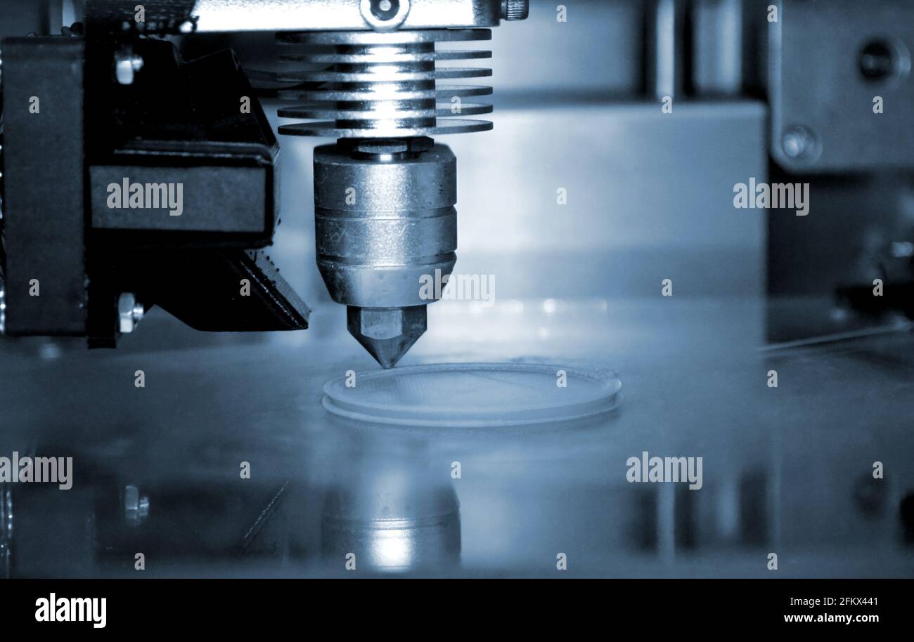 3D printer prints from the plastic figure closeup. 3D printer makes ...