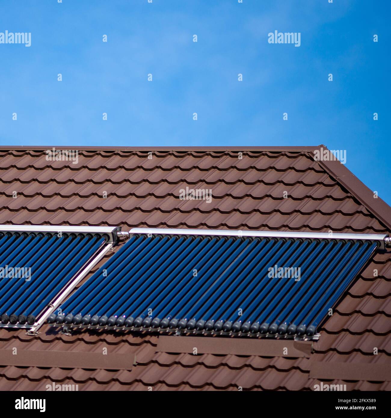 Solar cell tube on brown tiled roof closeup Stock Photo - Alamy