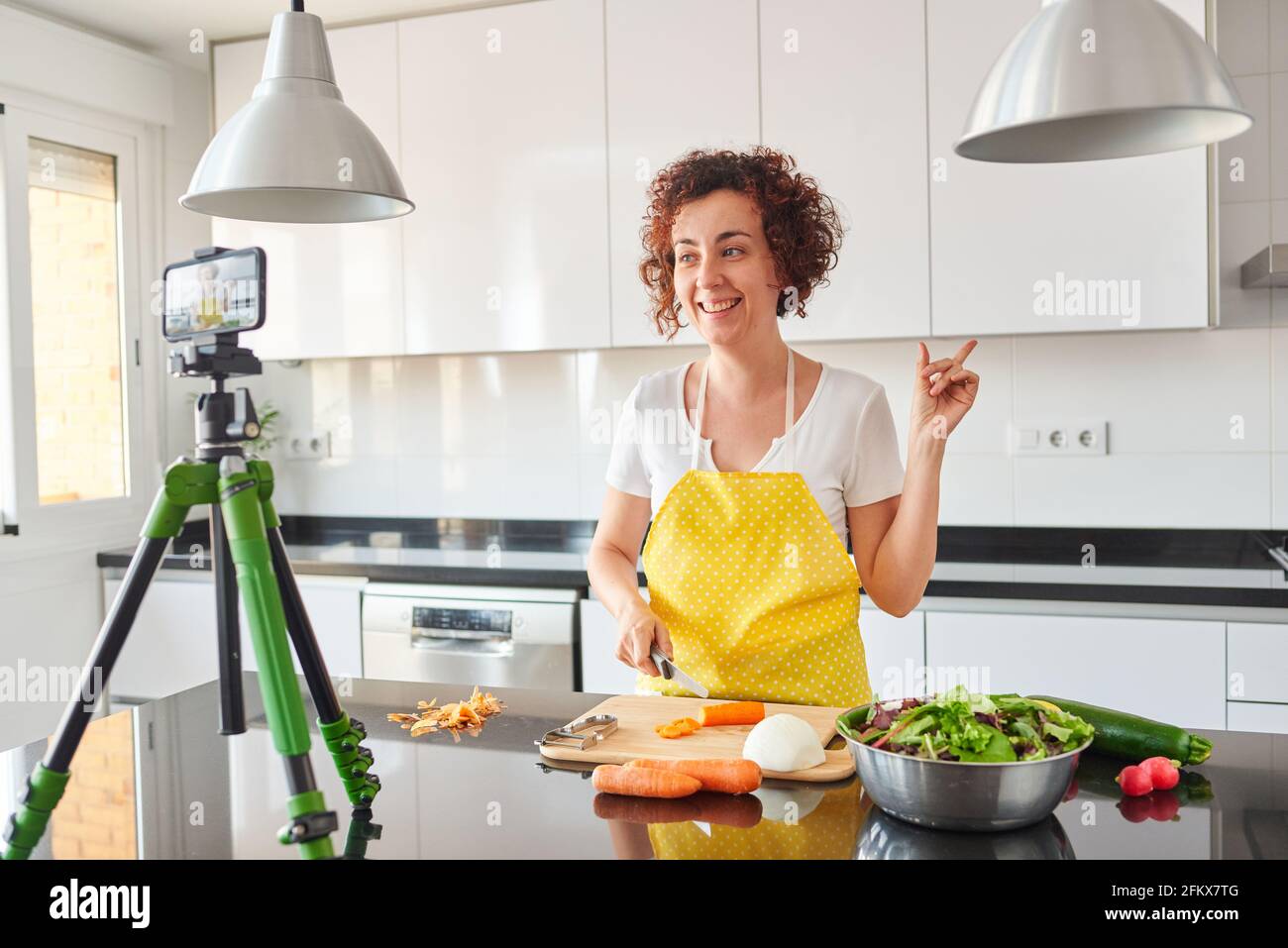 Woman youtuber records herself with a camera in the kitchen of her ...