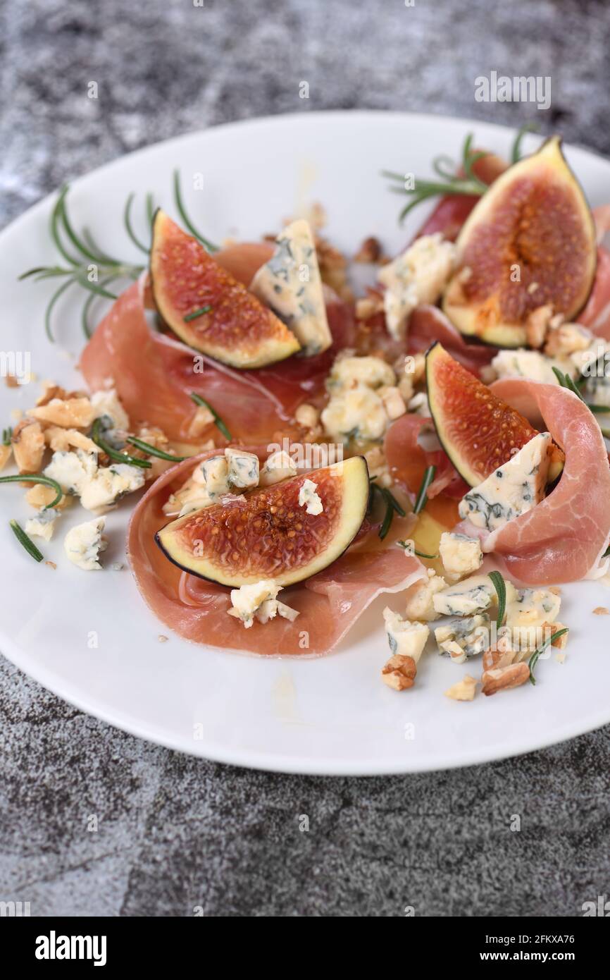 Figs with Parma ham with blue cheese, nuts and honey Stock Photo - Alamy