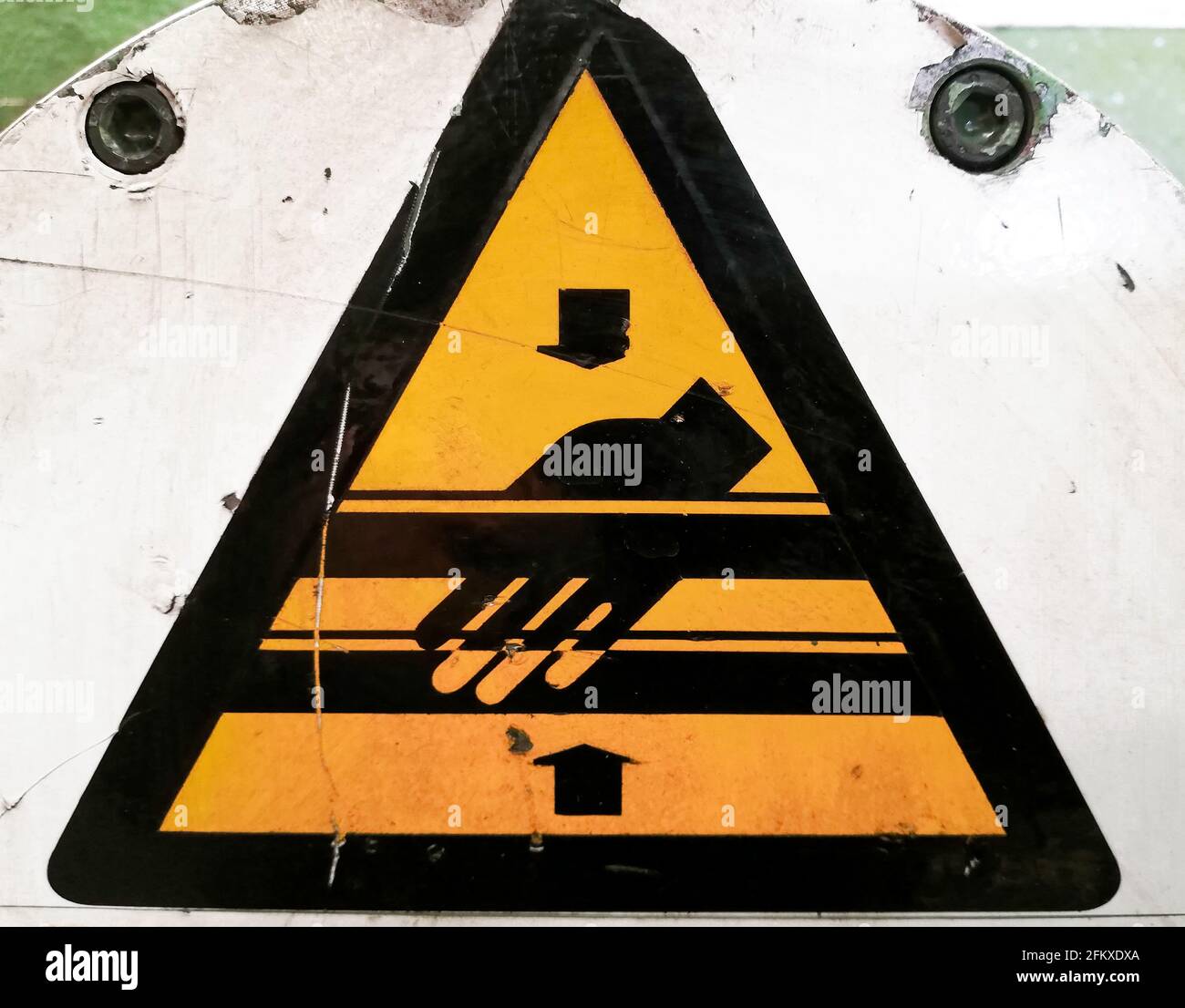 Black and yellow warning sign and danger of entrapment and cutting of ...