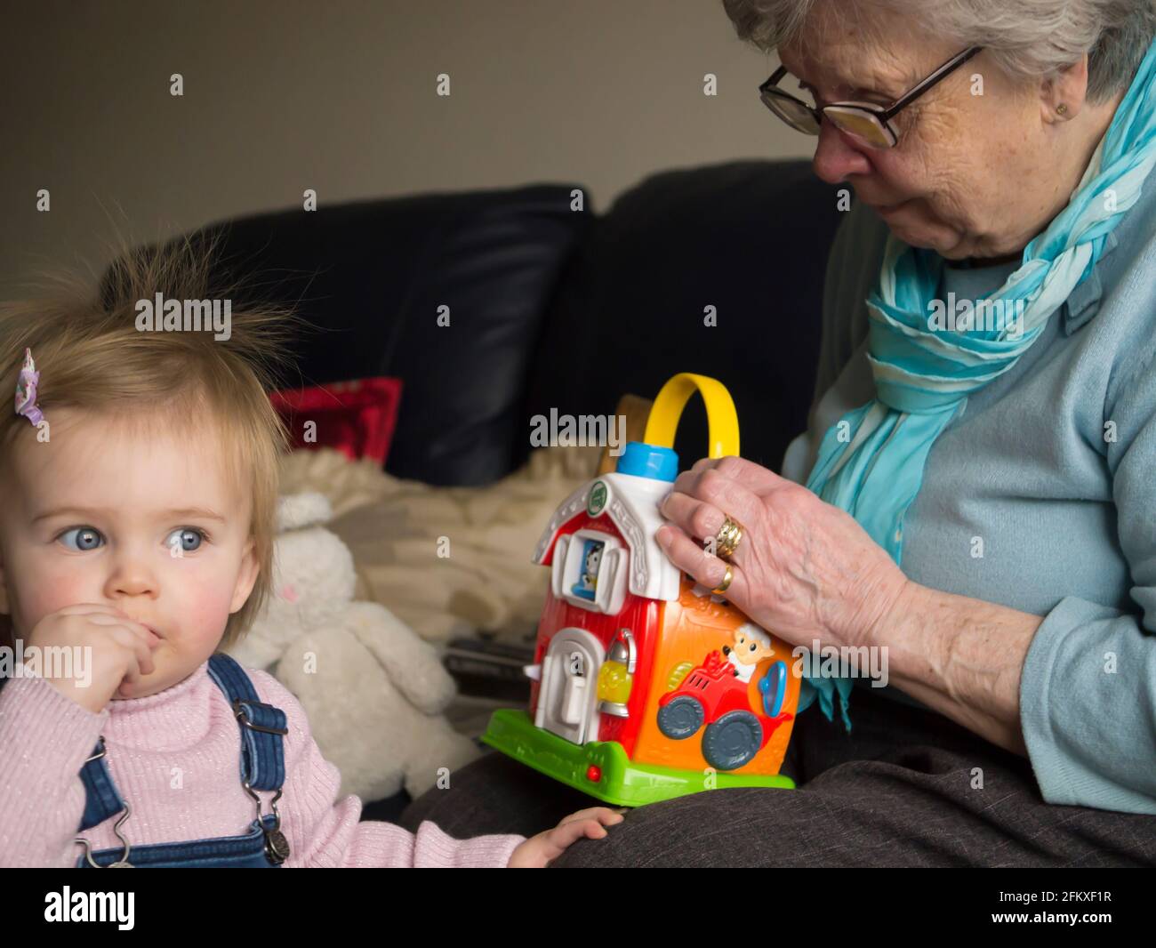 Toddler playing with Great Grandmother Stock Photo - Alamy