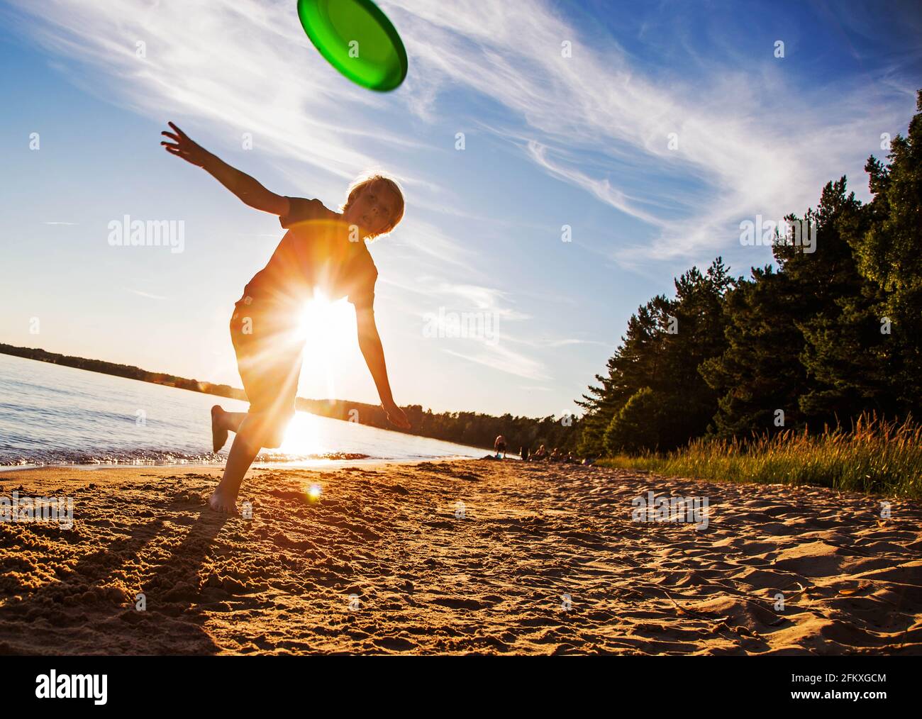 A little guy throwing a frisbee on the beach, Motala, Sweden Stock ...