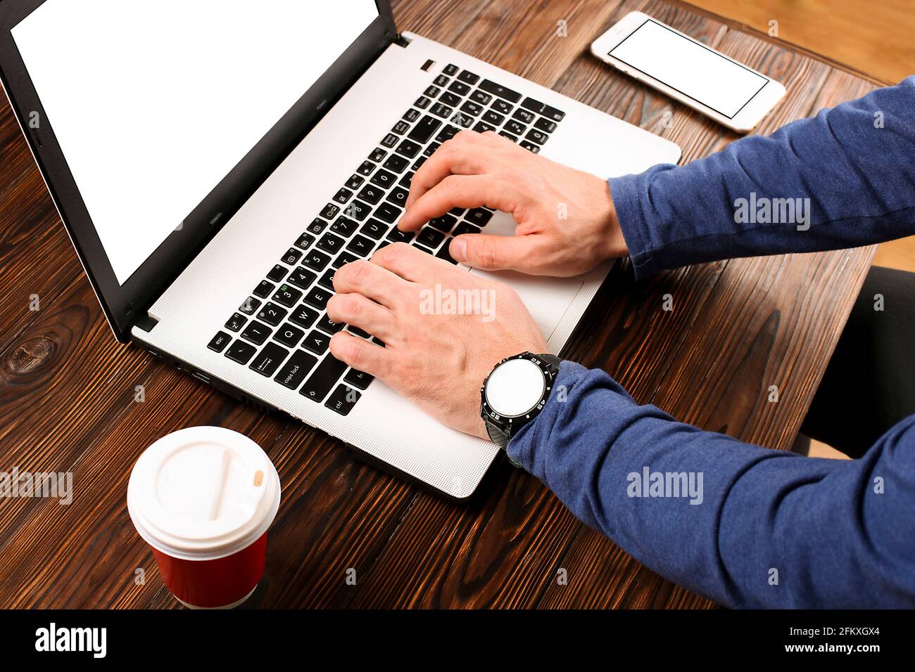 Close up of male hands wearing wrist watch typing on pc laptop computer ...