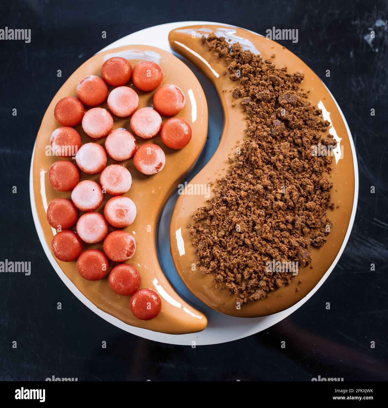 Wonderful delicious yin-yang-shaped cake in the home kitchen on a black ...