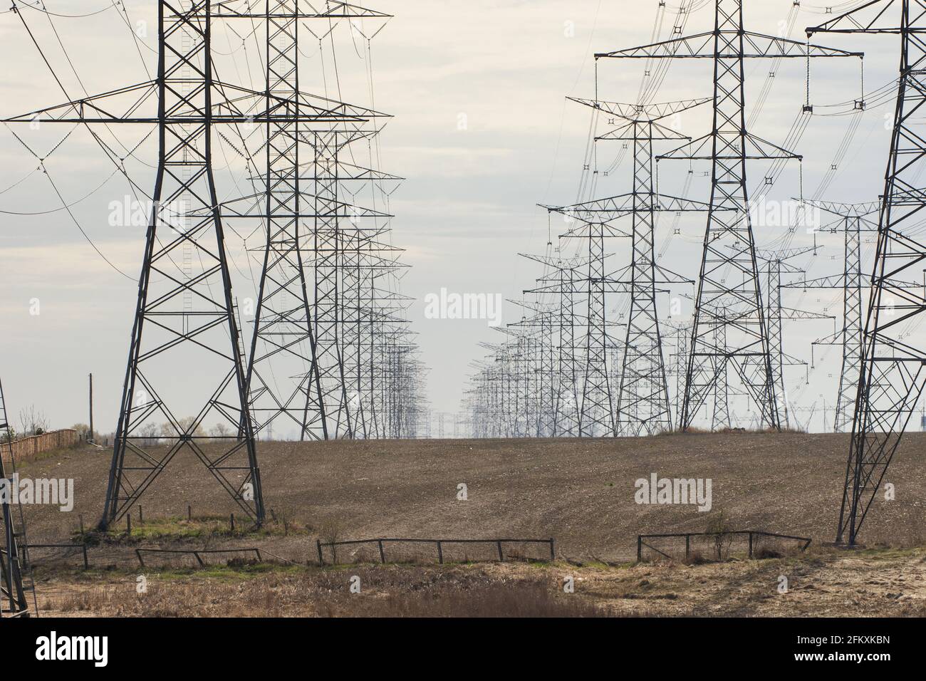 Parrallel High tension power lines running through a barren landscape ...