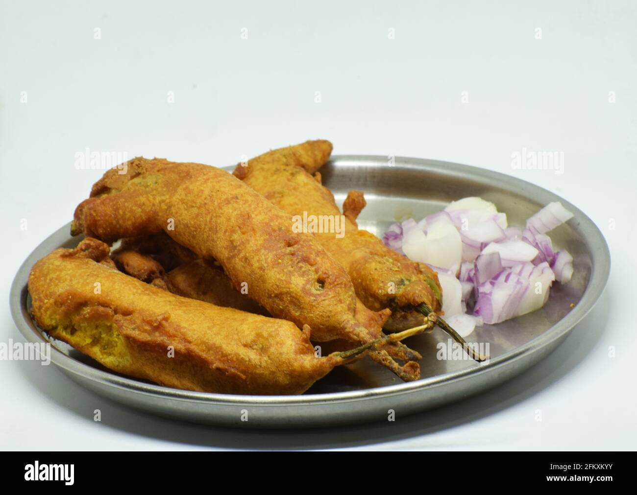 Closeup shot of deep-fried chili fritters with fresh-sliced onions on a ...