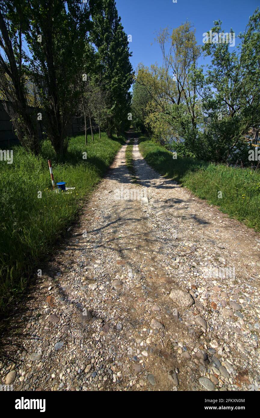 Path in a park next to a boundary wall of a factory in the italian ...