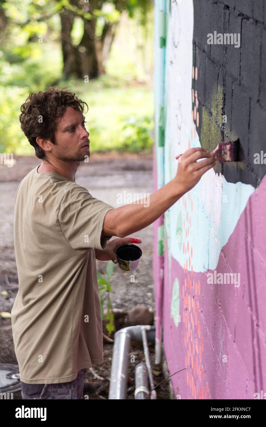 Concentrated male artist painting mural on wall Stock Photo - Alamy