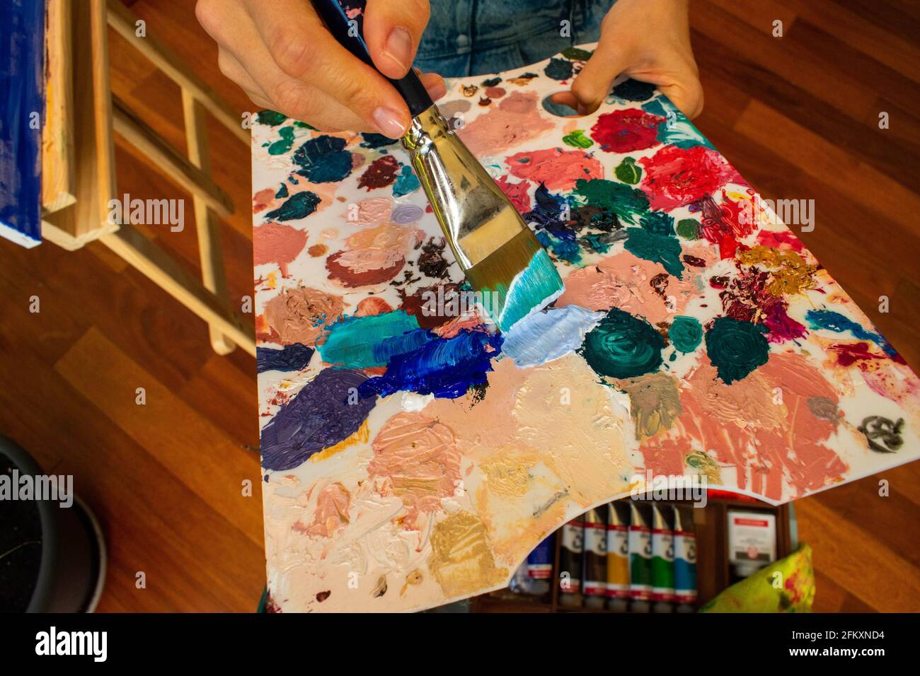 brush taking paint from color palette Stock Photo - Alamy