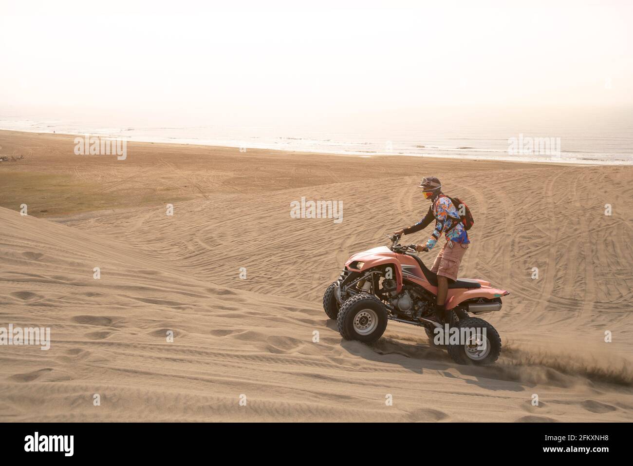 Man riding a quad bike on a sand dune of a Mexican beach (Chachalacas ...