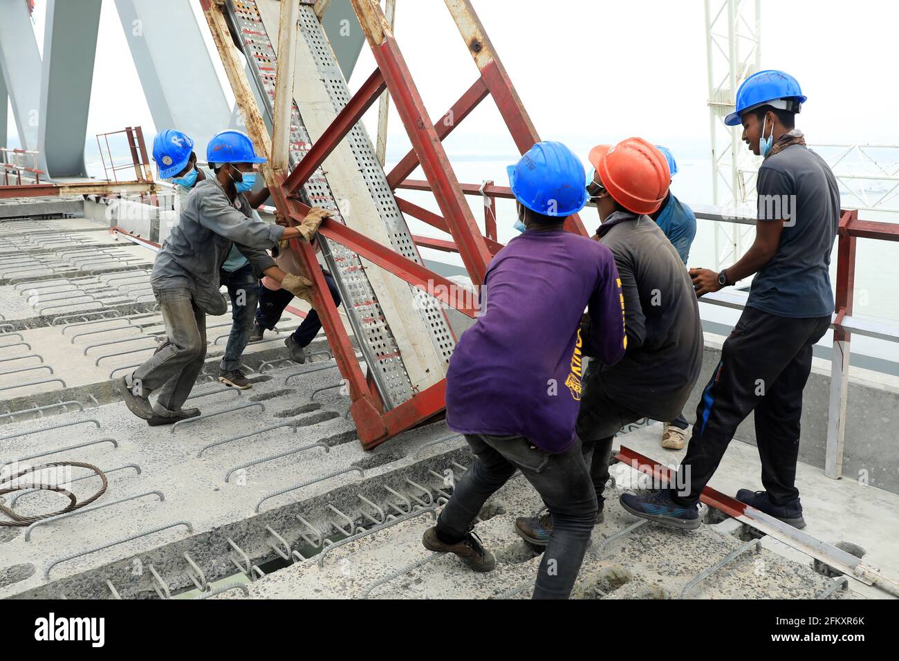 Workers seen working on the Padma bridge.The Planning Commission is ...