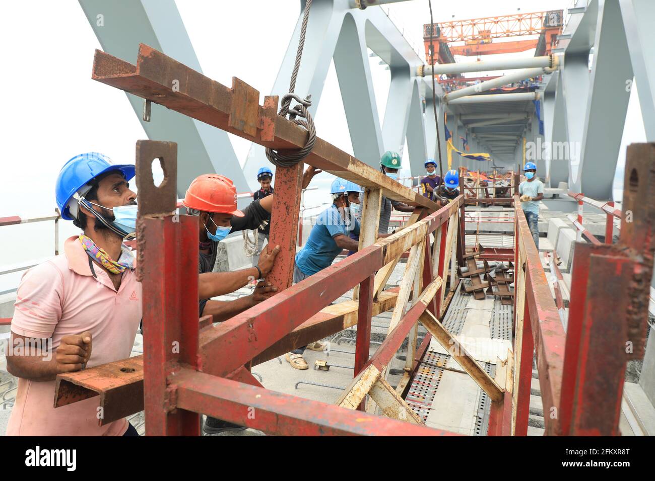 Workers seen working on the Padma bridge.The Planning Commission is ...