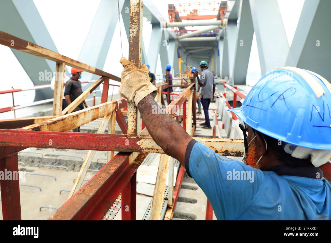 Workers seen working on the Padma bridge.The Planning Commission is ...