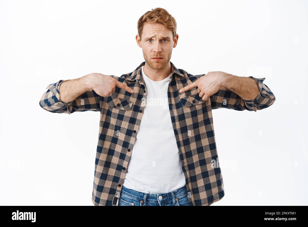 Sad redhead man pointing at himself with pleading desperate look ...