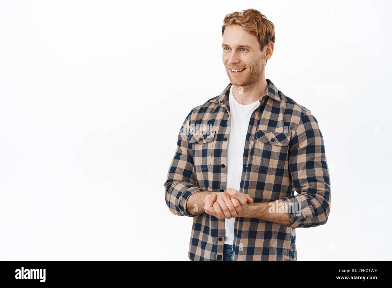 Handsome friendly-looking redhead man, holding hands together in polite ...
