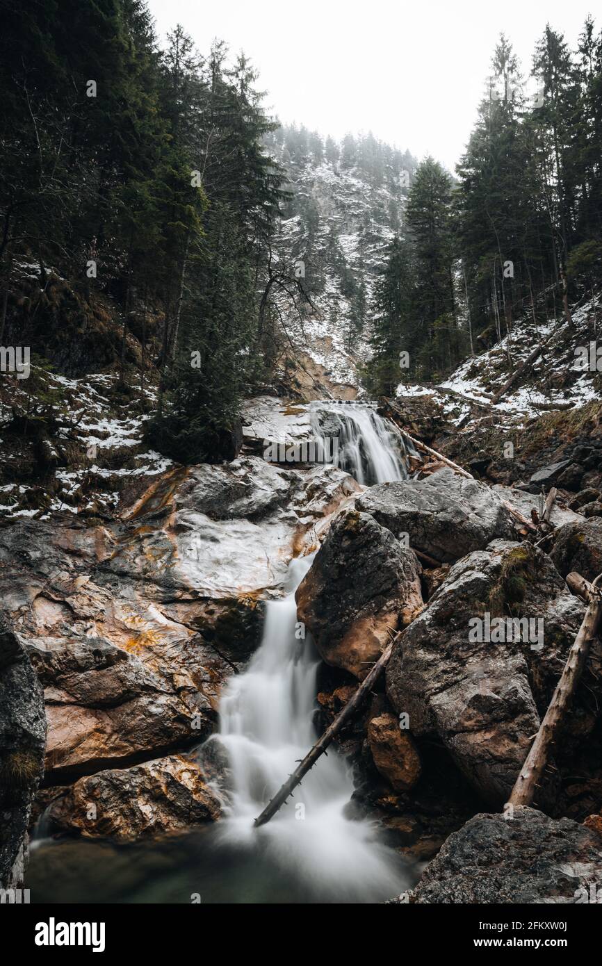 Beautiful scenery of a powerful waterfall flowing through rocky cliffs ...