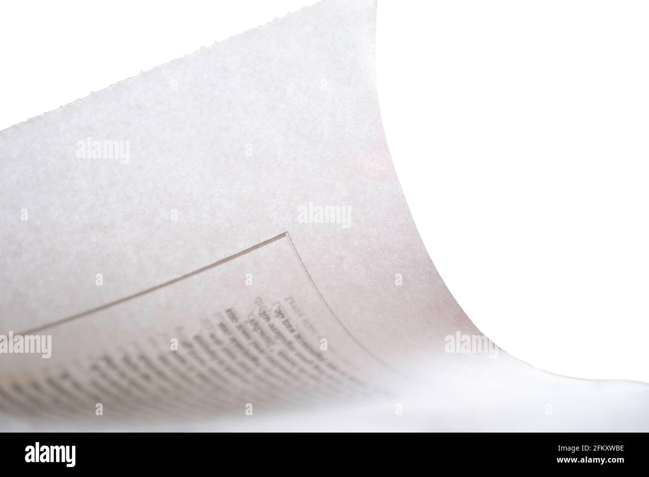 Folded corner of the slightly translucent paper of a newspaper with ...