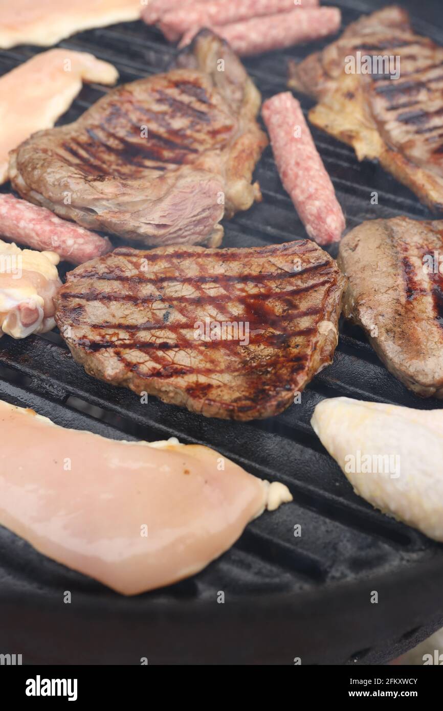 Process of making barbecue with meat fillets on a grill Stock Photo - Alamy