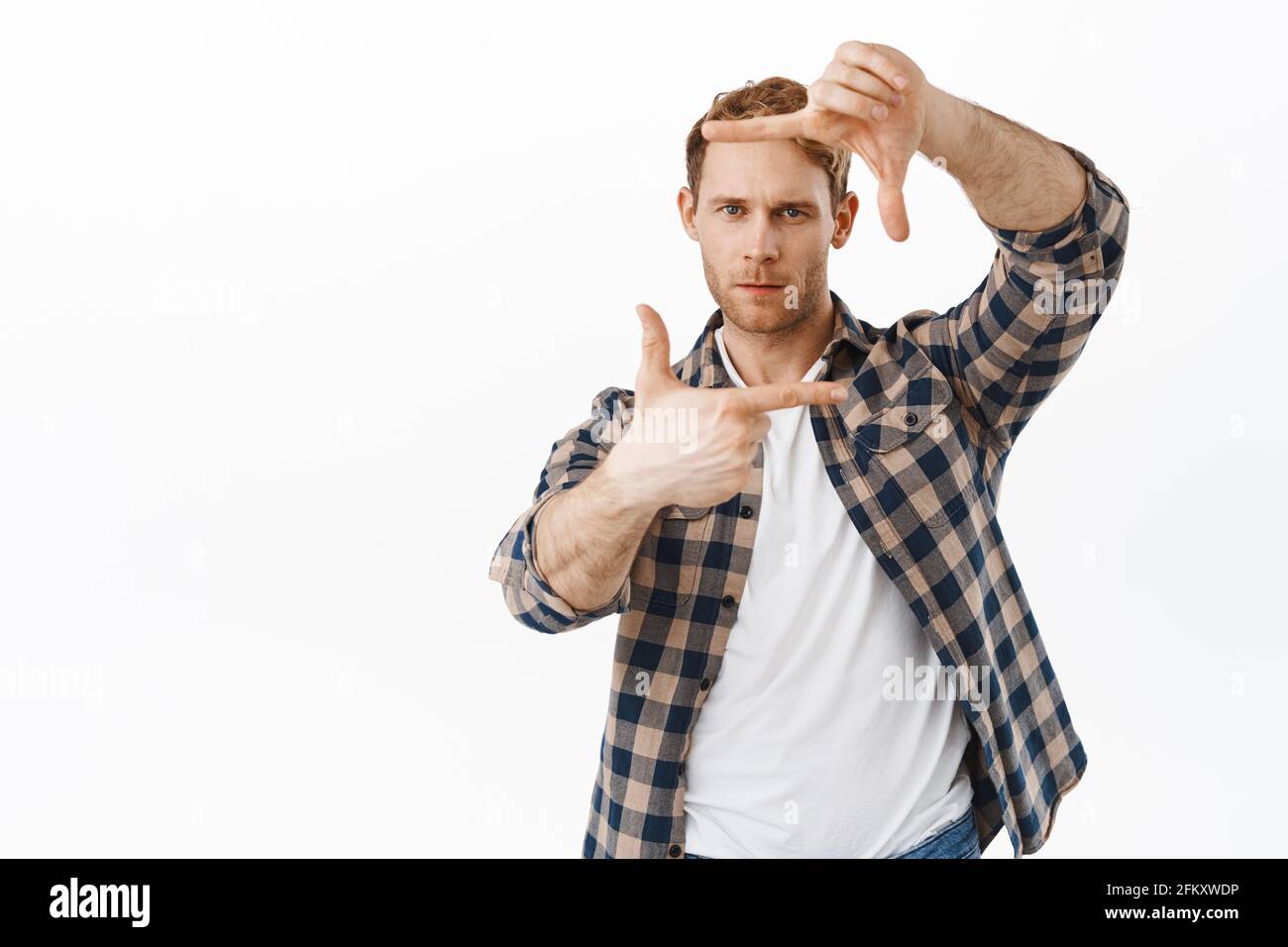 Serious man looks through hand frames, searching perspective, perfect ...