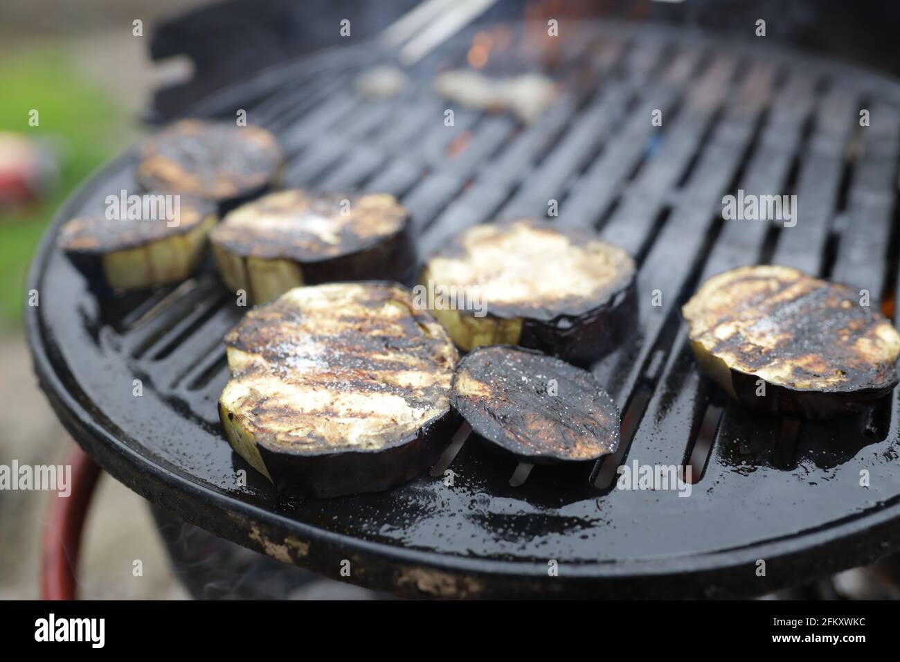 Process of making barbecue with meat fillets and vegetables on a grill ...